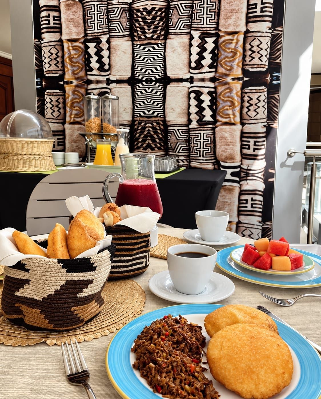Uma mesa de café da manhã com pão, frutas e café.