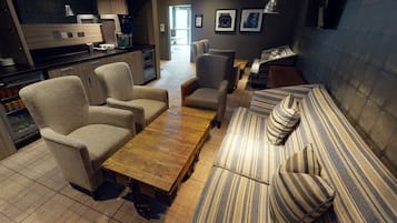 Uma sala de estar moderna com uma mesa de centro de madeira, sofá listrado e cadeiras de vime.