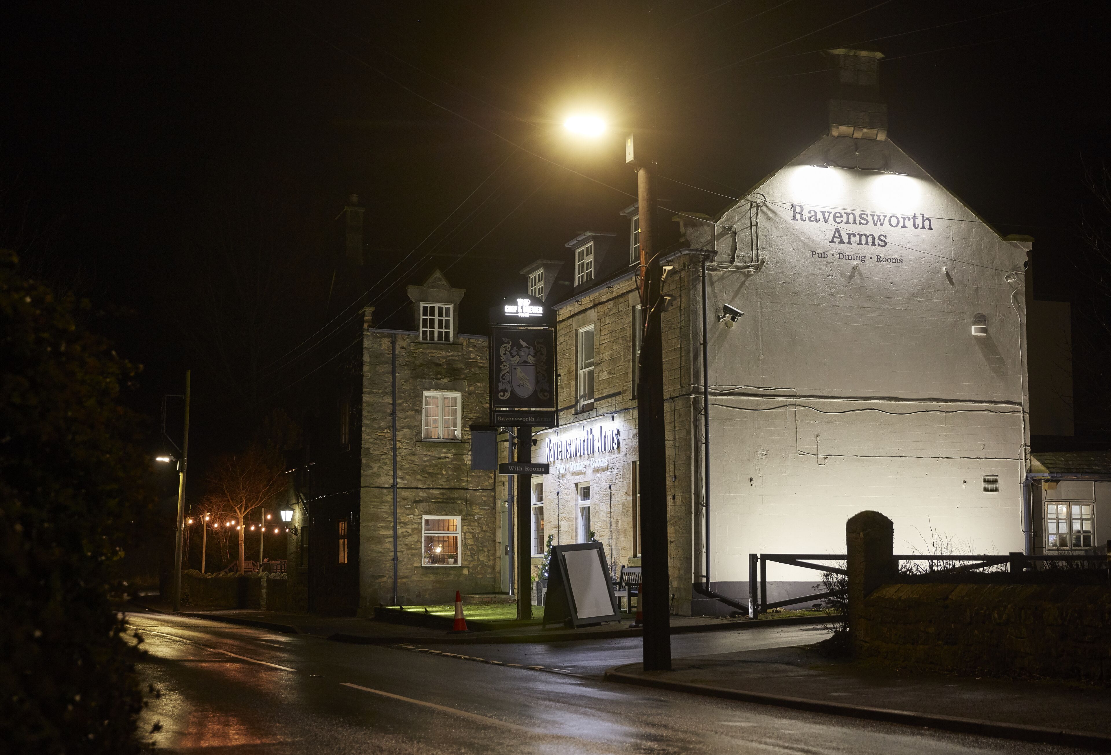 Um edifício histórico com uma placa bem visível que diz 'Ravensworth Arms', indicando que se trata de um pub e restaurante.