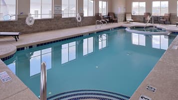 Piscina interna com água cristalina, várias pistas e placas de segurança.