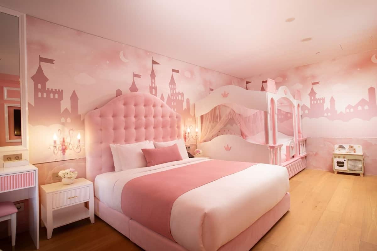 Quarto com cama grande, mesa de cabeceira, cômoda e penteadeira com espelho.
