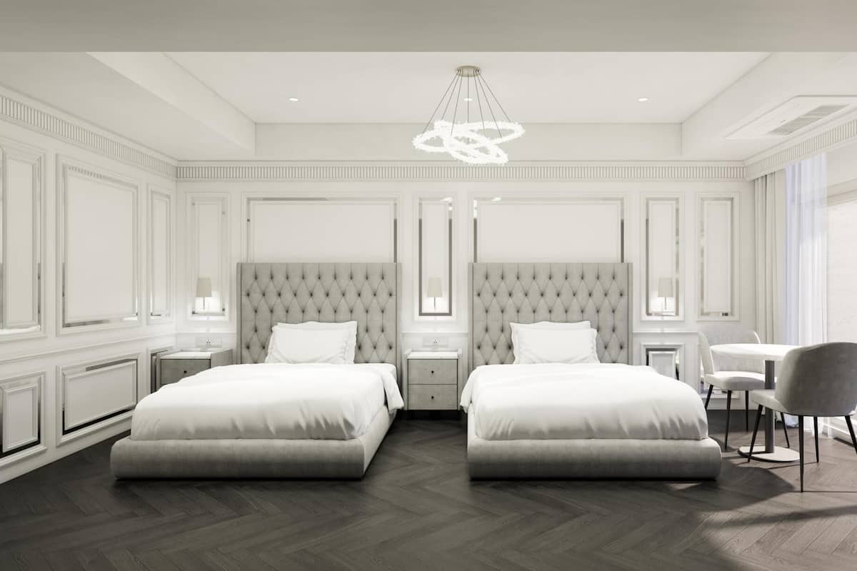 Quarto com cama de casal, lustre, escrivaninha e uma cadeira.