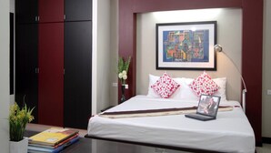 Quarto de hotel moderno com uma cama grande, uma escrivaninha e um guarda-roupa.