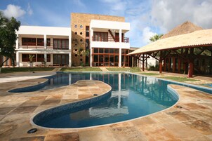 Um edifício moderno com piscina, janelas amplas e área coberta.