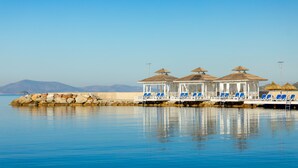 Um resort à beira-mar com áreas de estar cobertas e um muro de pedra.