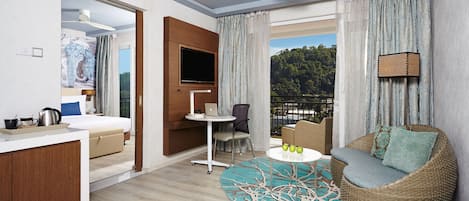 Quarto de hotel moderno com varanda, área de refeições e sala de estar com sofá e mesa.