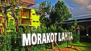 Placa de Morakot Lanta com um edifício moderno ao fundo.
