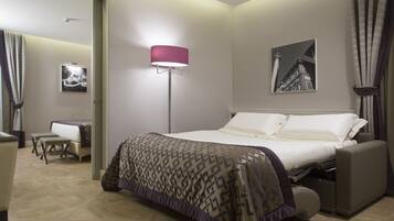 Quarto de hotel com cama, escrivaninha, cadeira e abajur.