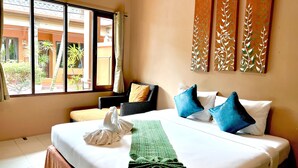 Quarto de hotel com cama, uma cadeira e vista para o exterior.