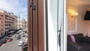 Quarto com vista para uma rua movimentada e um edifício histórico.