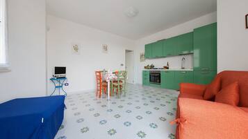 Um espaço compacto com cozinha compacta, área de refeições e sofá.