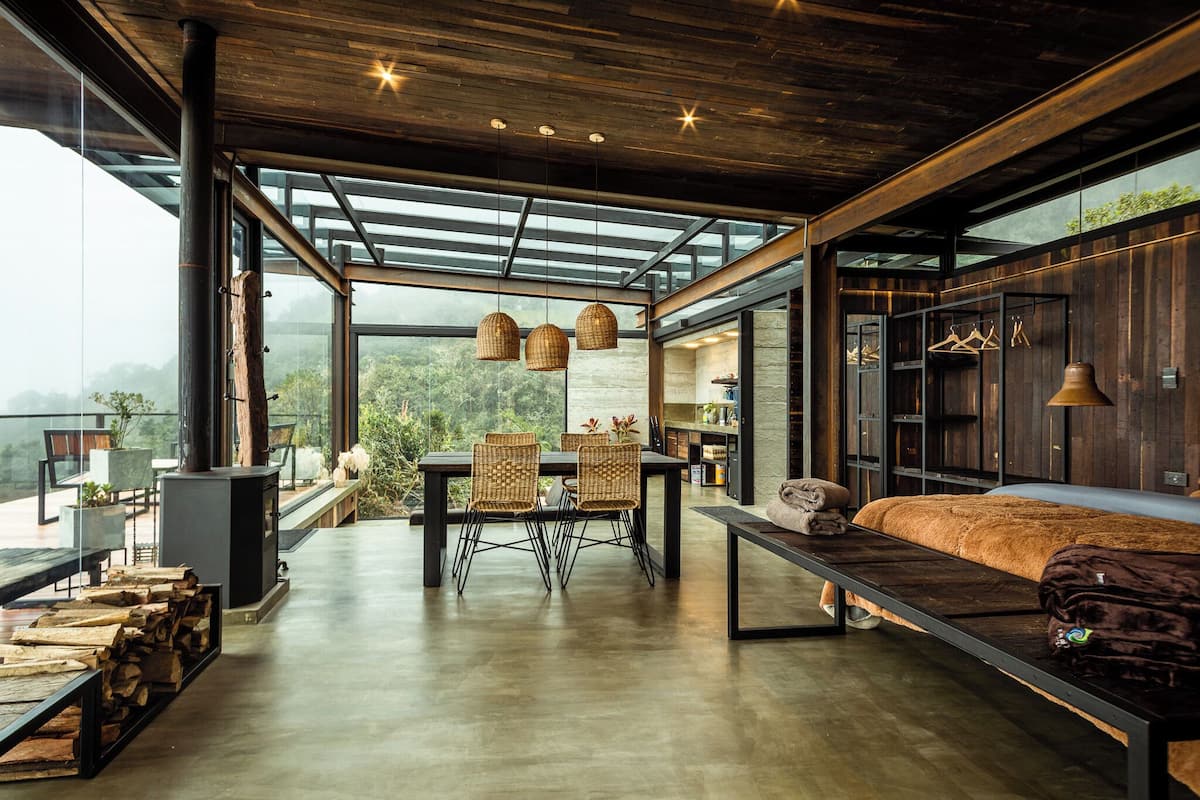 Um interior moderno com área de jantar, sofá e lareira.
