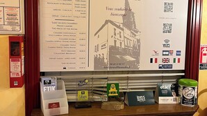 Placa de hotel com tarifas de quarto, horário de funcionamento e comodidades.