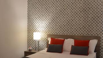 Cama bem arrumada com um suporte de objetos, luminária de cabeceira e papel de parede estampado.