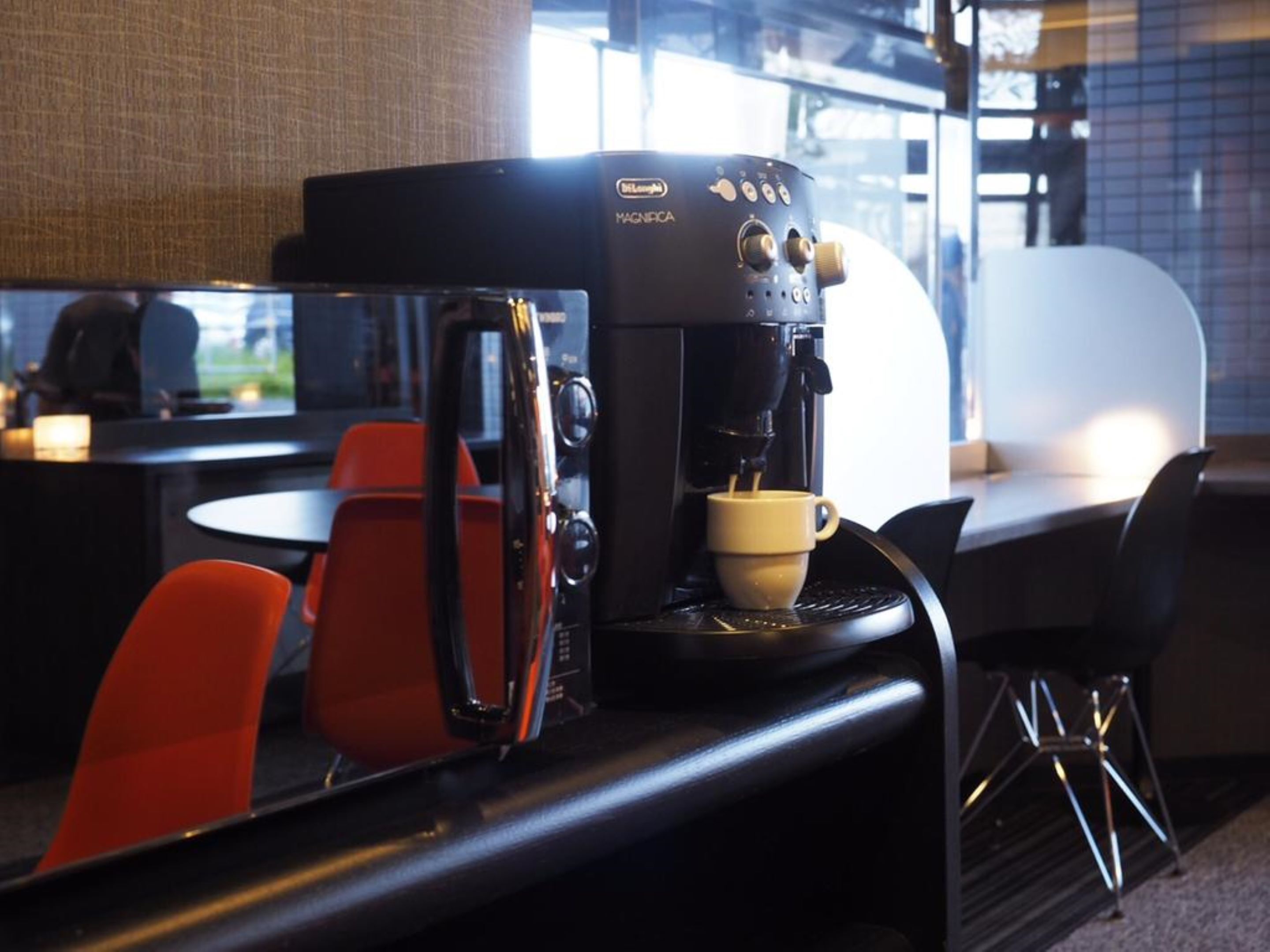 Máquina de café com uma chávena de café sobre uma mesa num café.