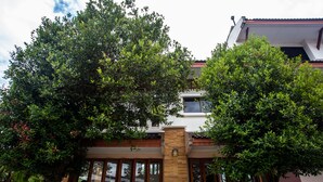 Uma casa moderna de dois andares, com amplas janelas e uma varanda.