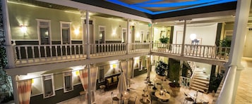 Um átrio de hotel com vários níveis, varandas, áreas de estar e uma fonte central.