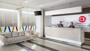 Uma área de recepção moderna com um sofá e um balcão de atendimento.