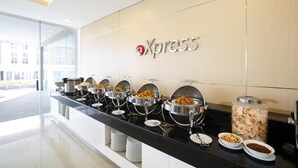 Uma área de buffet com vários pontos de alimentação e uma placa da marca na parede.