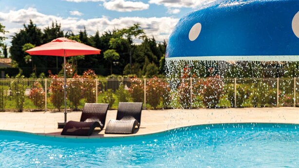 Piscina com espreguiçadeiras e um guarda-sol vermelho.