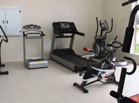 Ginásio com esteira, elíptica e bicicleta ergométrica.