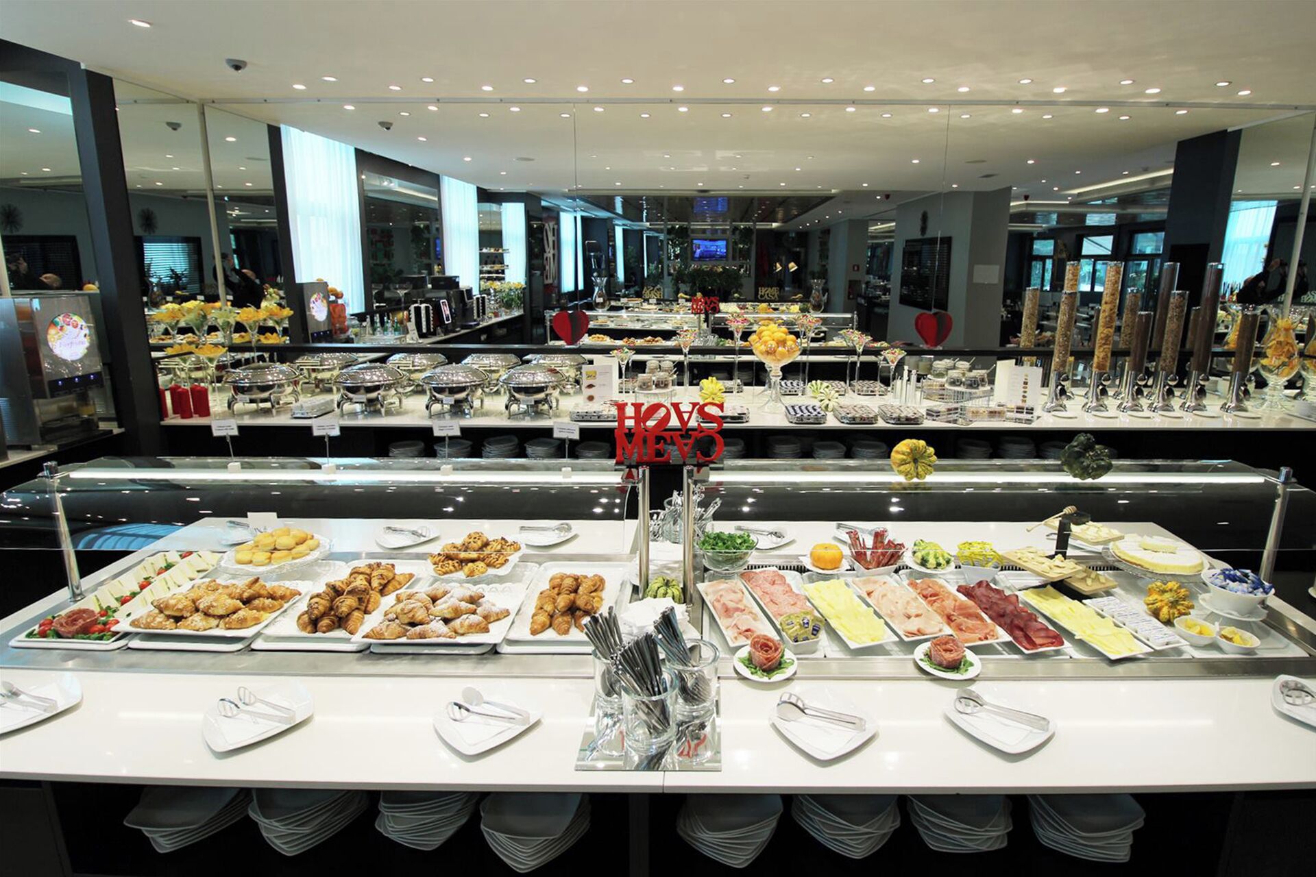 Um buffet com diversos alimentos e utensílios.