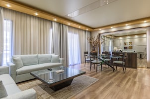 Suite Familiar, 2 quartos, fumadores, kitchenette | Sala de estar | Televisor LCD 