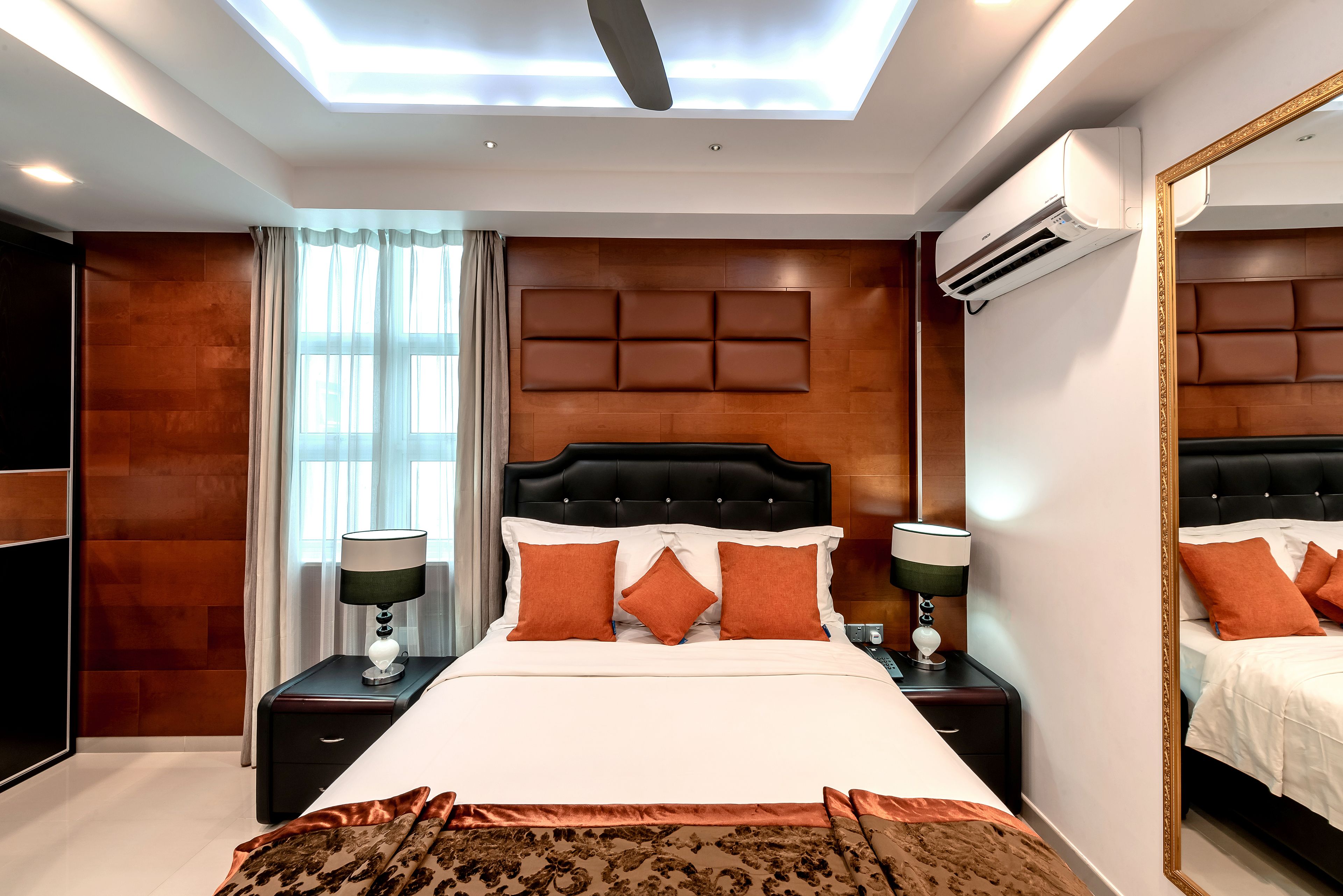 Quarto de hotel moderno com uma cama grande, cabeceira de madeira e um claraboia.