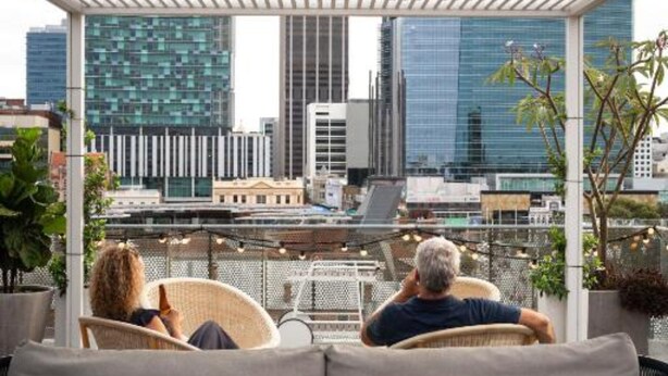 Uma área de estar no terraço com vista para a cidade.
