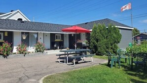 Um motel com varanda coberta, área de estar externa e uma bandeira.