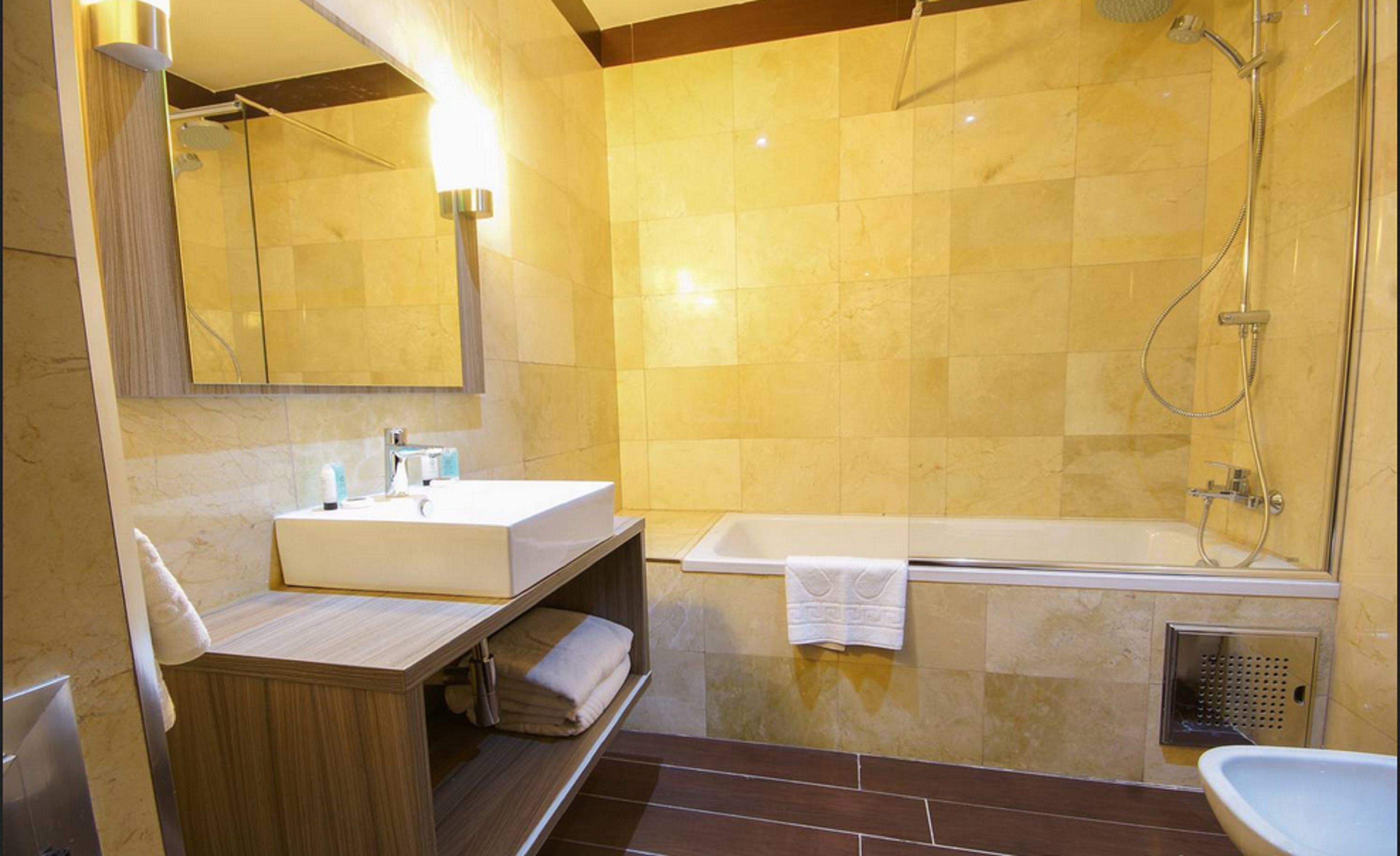 Casa de banho moderna com lavatório, toucador, espelho e zona de duche.