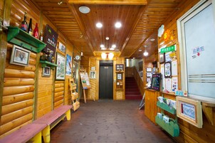 Interior de madeira com bancos, escadas e diversos painéis informativos.