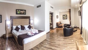 Quarto de hotel com uma cama grande, um sofá e uma área de jantar.