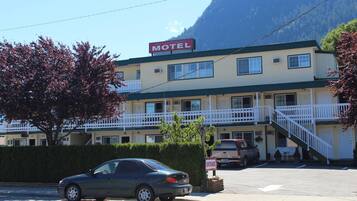 Um motel com estrutura em dois andares, uma varanda e uma escadaria que leva à entrada.