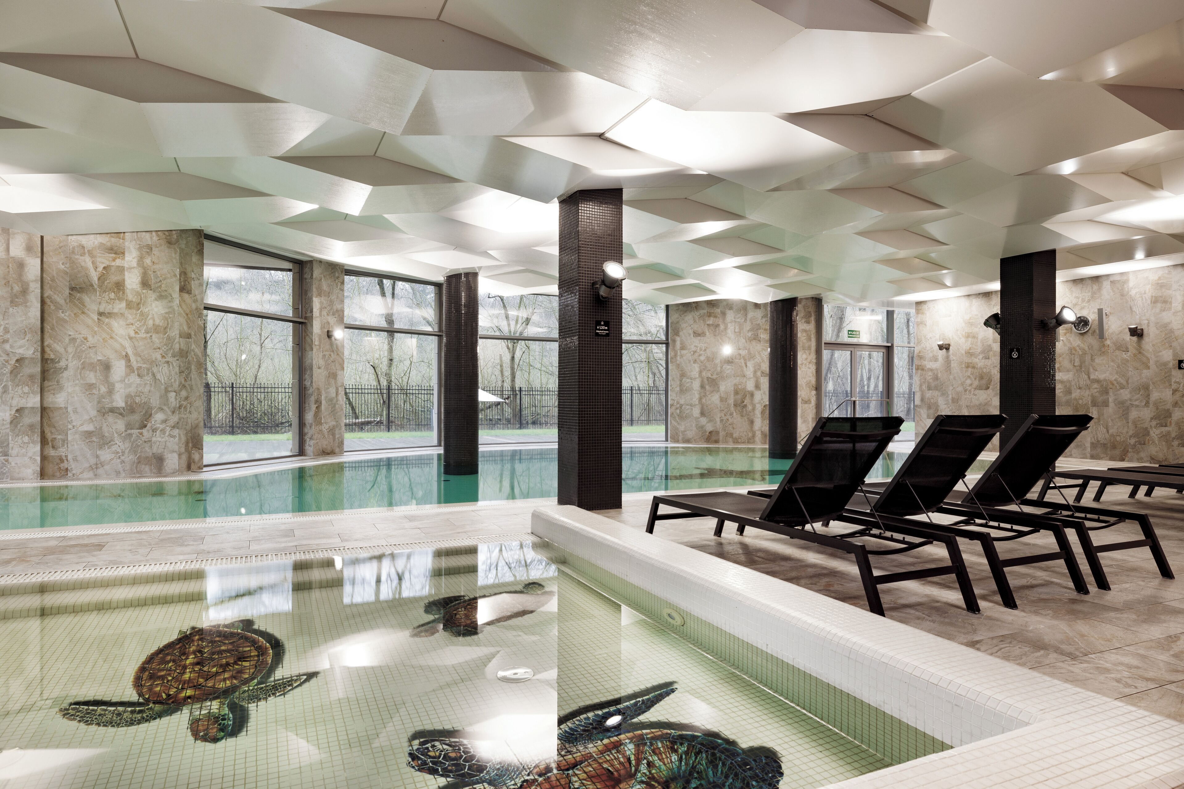 Uma piscina com espreguiçadeiras e uma escultura de tartaruga.