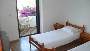 Um quarto com uma cama de madeira, uma mesa de cabeceira, uma cadeira e uma televisão.