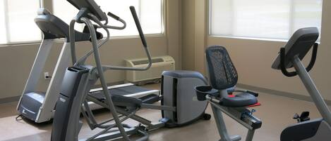 Academia com esteiras, bicicleta ergométrica e remo.