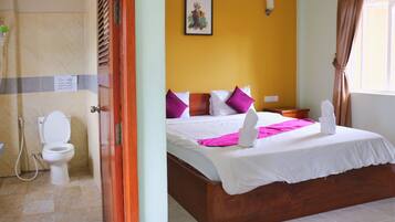 Quarto de hotel com uma cama, banheiro e chuveiro.