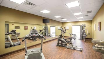 Uma academia com esteiras, elípticos e equipamentos de musculação.