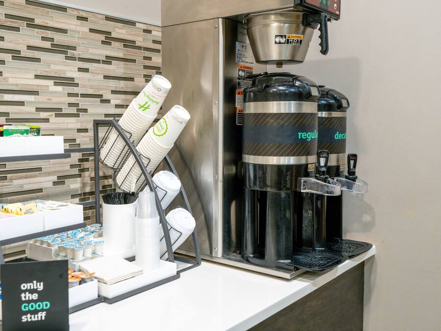 Uma estação de café com máquina de café, chávenas e um letreiro com a inscrição 'só o melhor'.