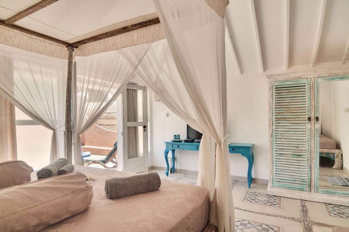 Quarto com cama, escrivaninha, cadeira e guarda-roupa.