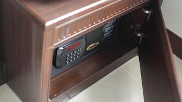 Uma mesa de madeira com telefone embutido e um pequeno painel de controle.