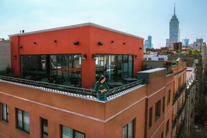 Um edifício vermelho com janelas grandes e uma varanda.
