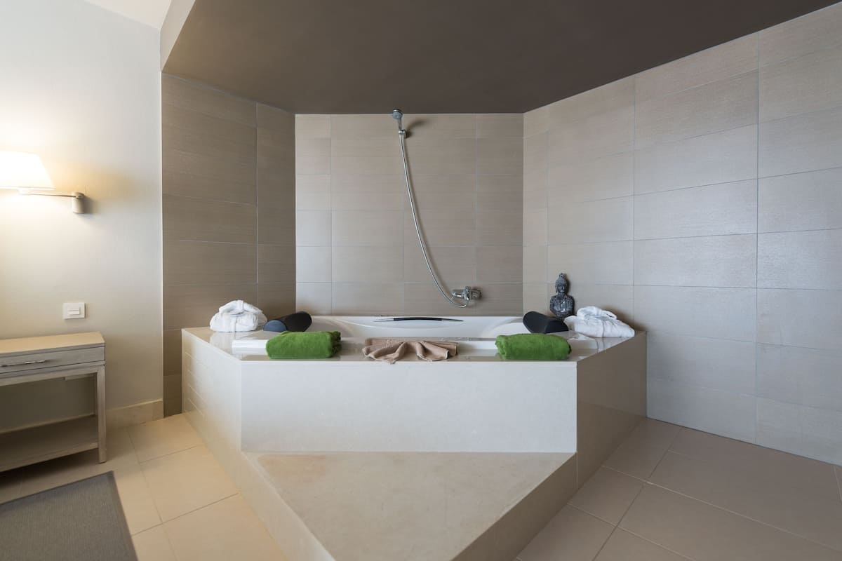 Uma casa de banho moderna com uma banheira independente, um chuveiro e um porta-toalhas.