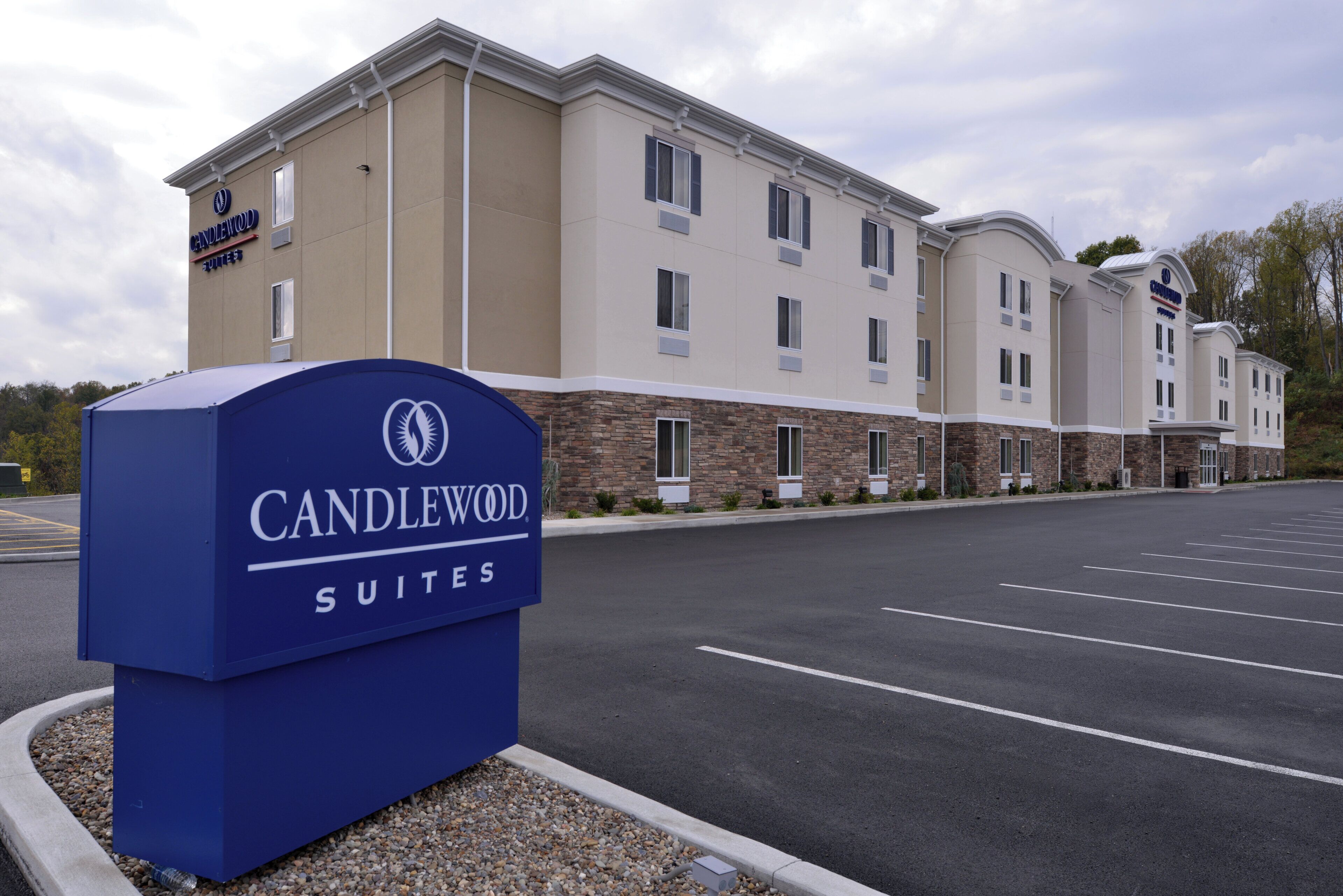 Placa de hotel para Candlewood Suites com um estacionamento à frente.
