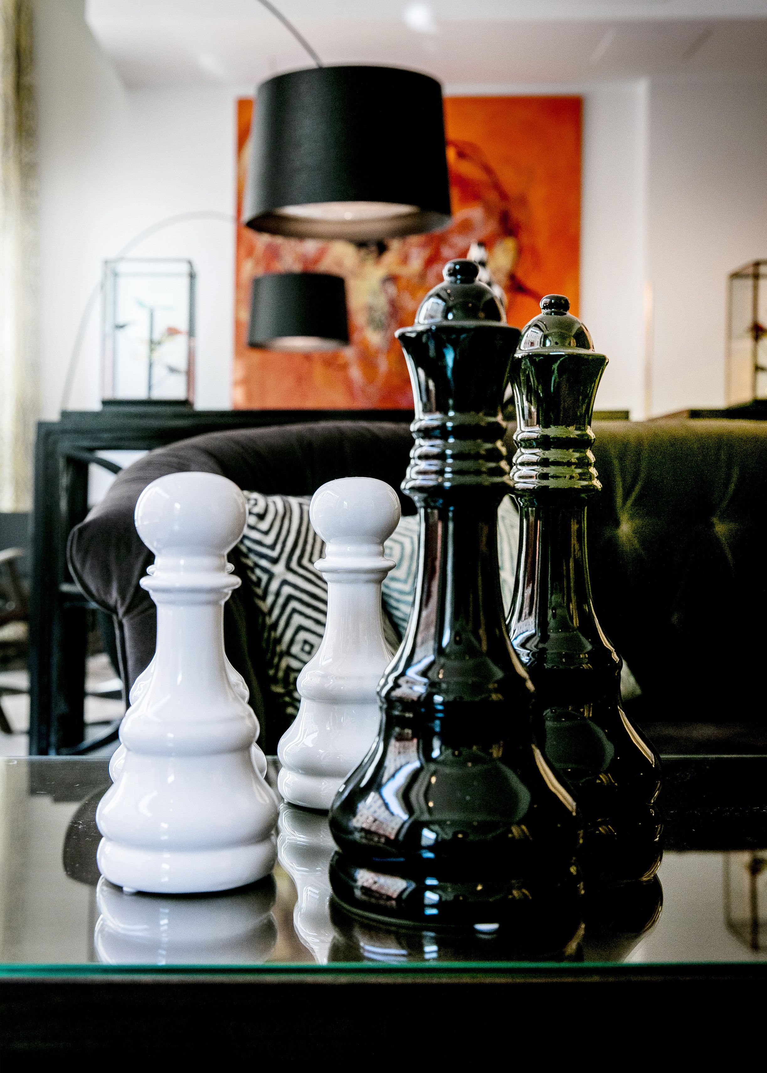 Uma mesa com saleiro e pimenteiro e um objeto decorativo.