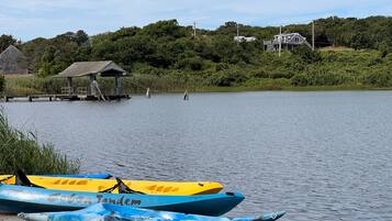 Um lago calmo com caiaques atracados na margem.