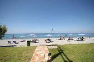 Na praia, espreguiçadeiras, guarda-sóis 