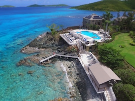 Resort com piscina, deck coberto e vista para o oceano.
