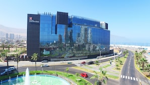 Um hotel moderno Hilton Garden Inn com fachada de vidro refletindo a paisagem urbana.